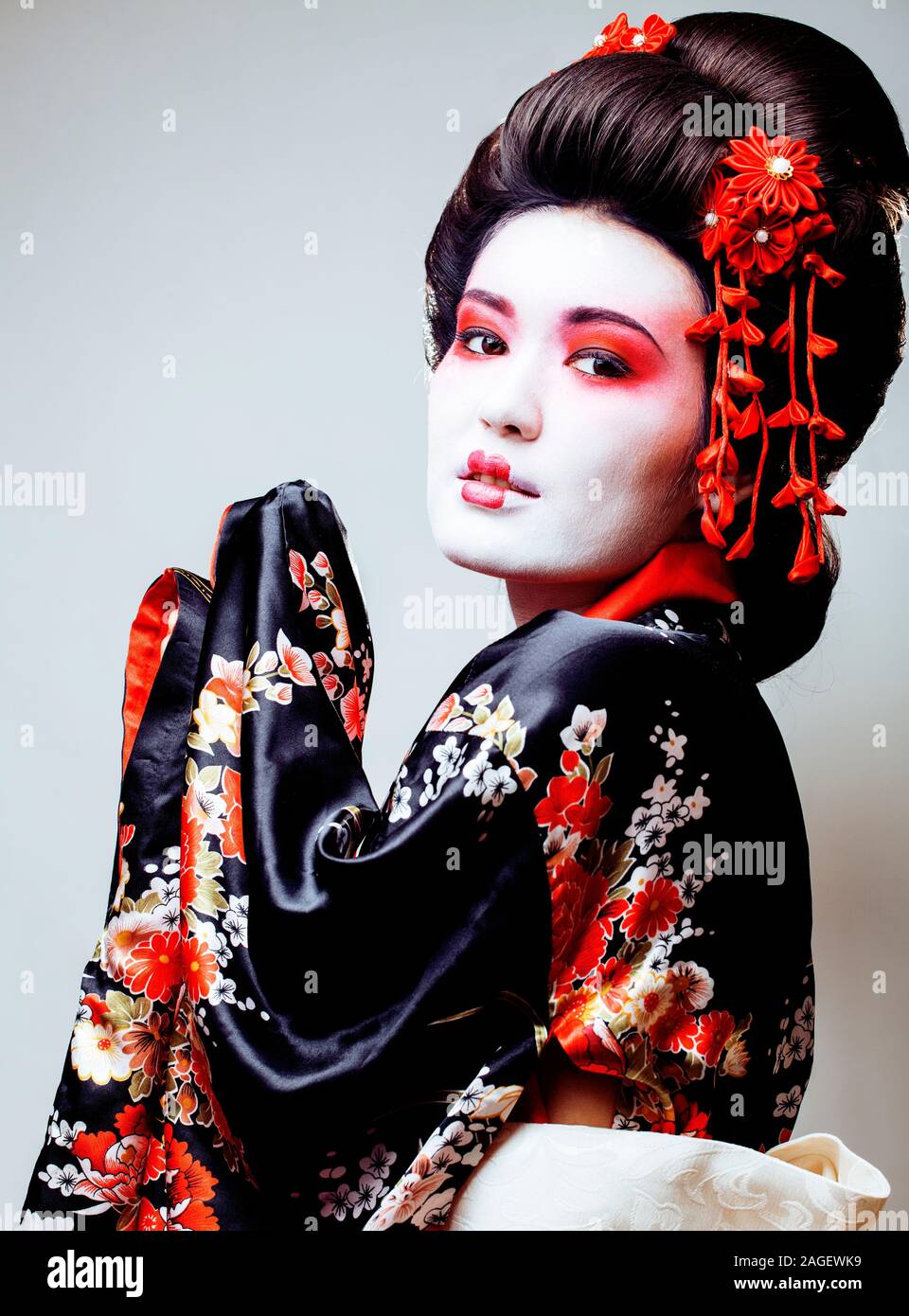 young pretty geisha in black kimono among sakura, asian ethno close up ...