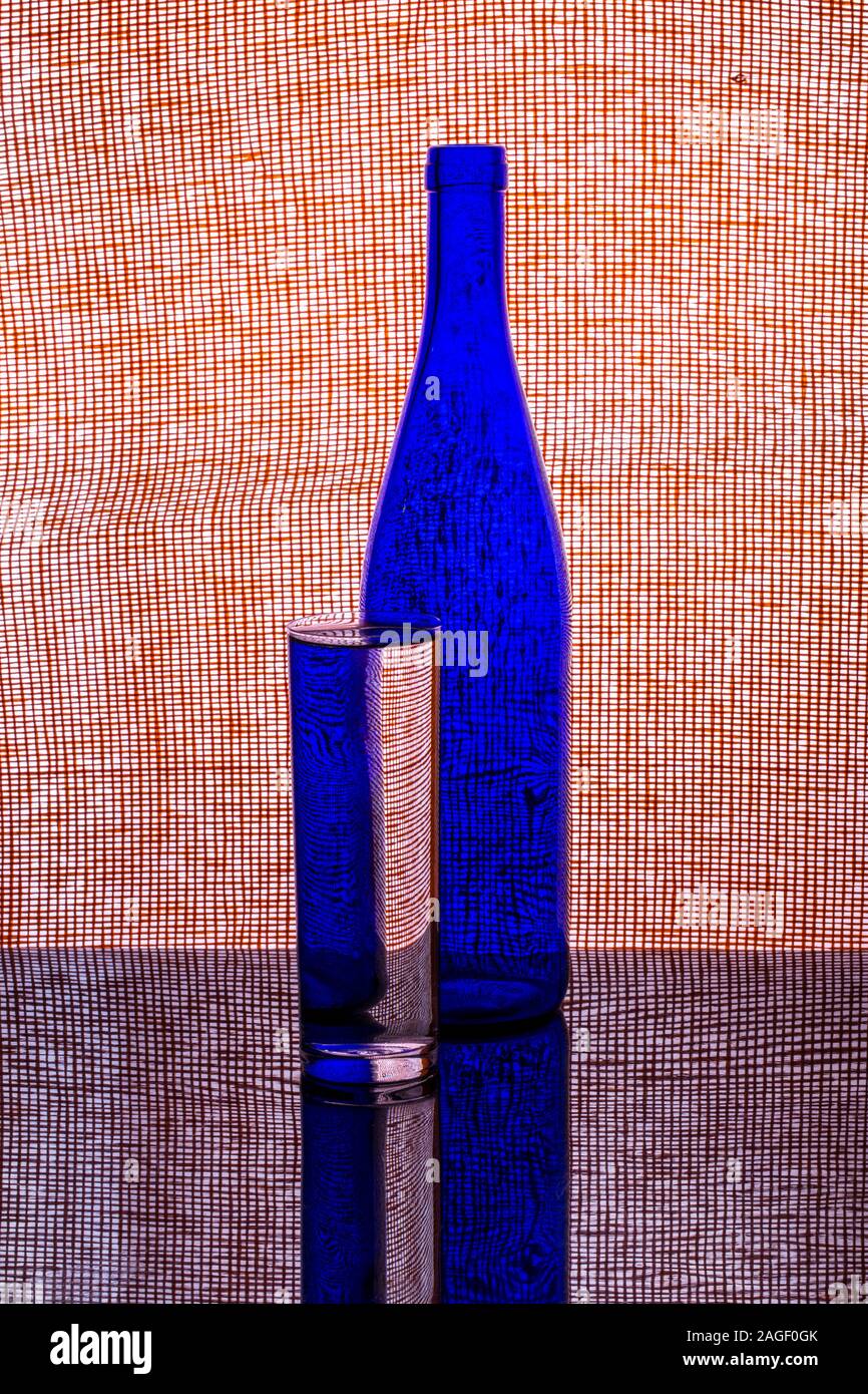 Still life with a blue bottle and a glass of water Stock Photo - Alamy