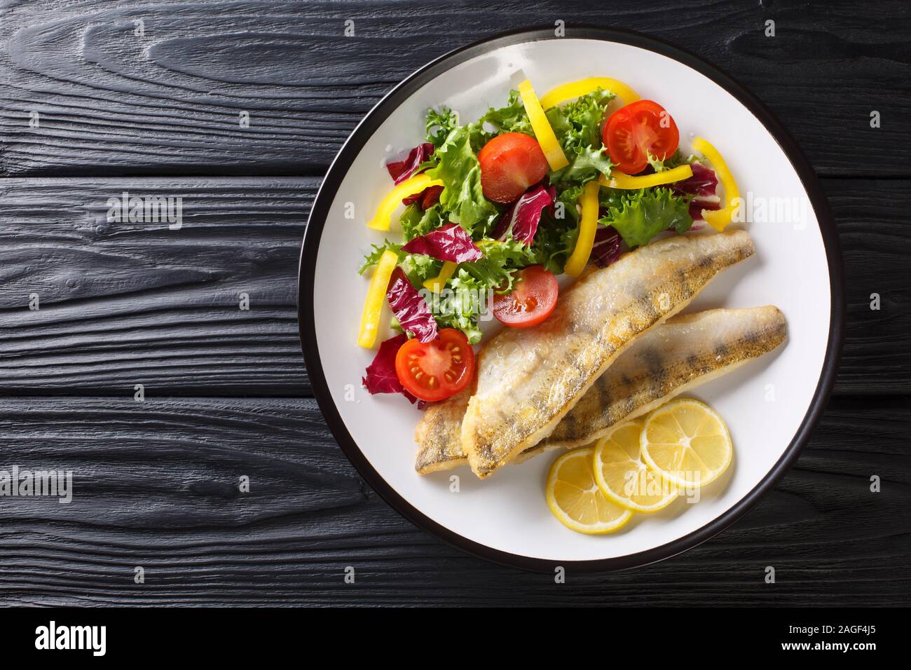 Freshwater fish fillet of zander fried with fresh vegetables and lemon ...