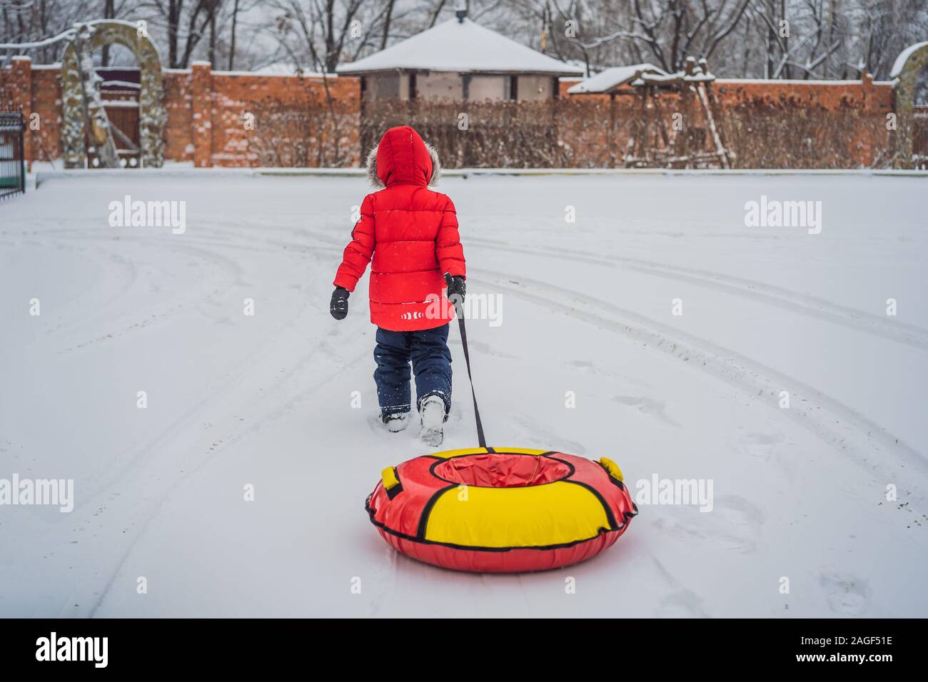 Child having fun on snow tube. Boy is riding a tubing. Winter fun for ...