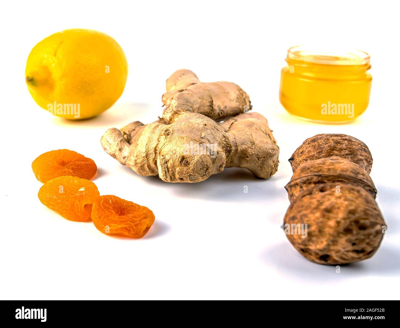 Honey, ginger root, lemon and walnuts on a white background. Food photo ...