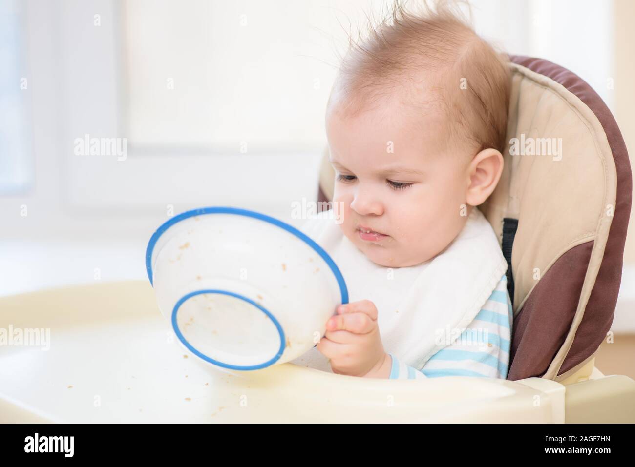 Kid eats mashed holding a plate in hand Stock Photo - Alamy