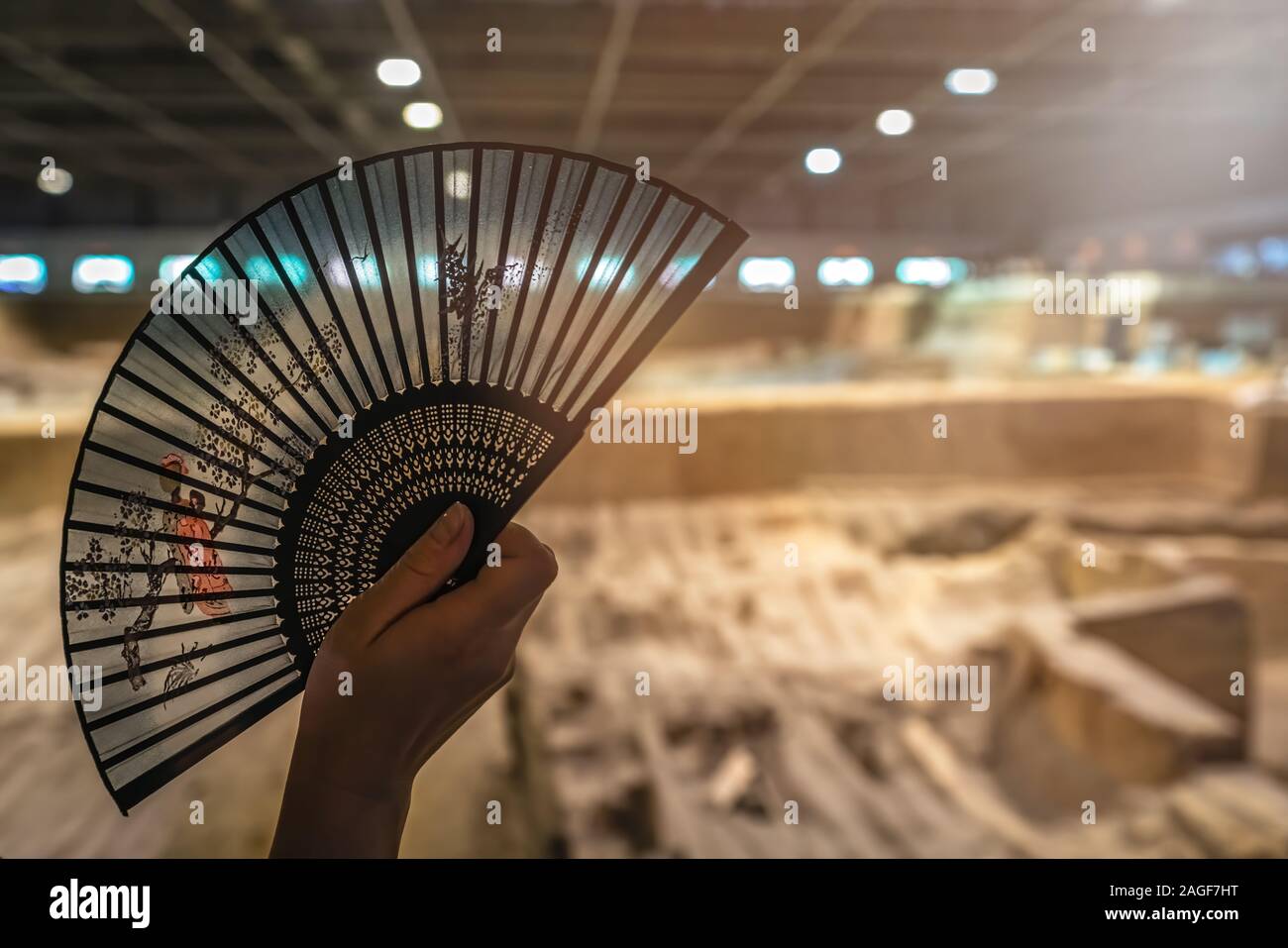 Woman holding chinese fan spread out inside the building in Terracota ...
