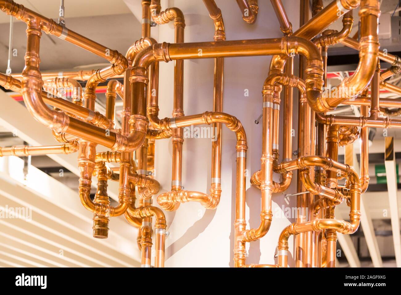 Copper pipes in an intricate formation against a white wall Stock Photo ...