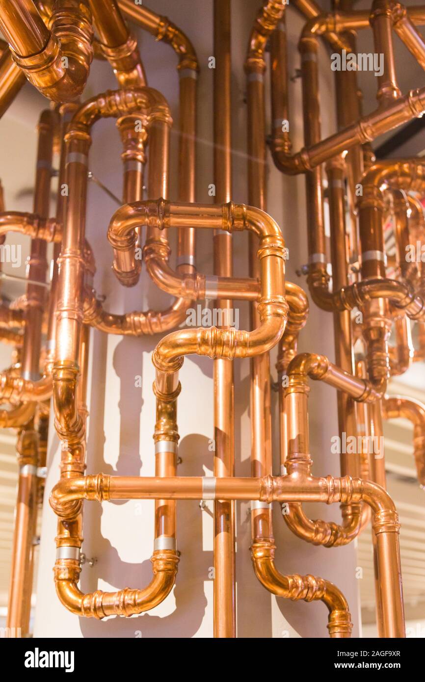 Copper pipes in an intricate formation against a white wall Stock Photo ...