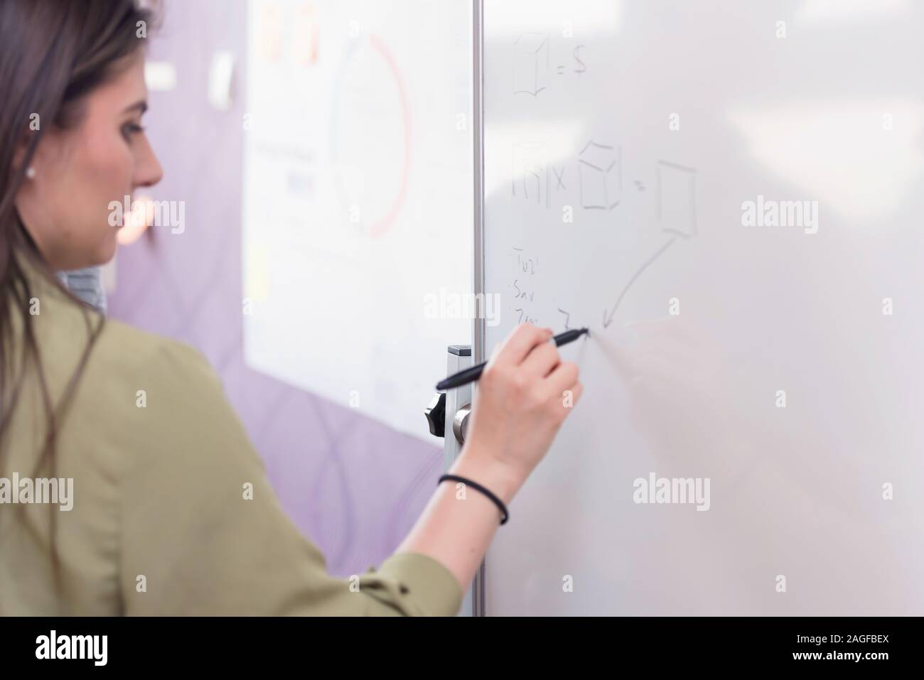 Young college female student writting on the chalkboard during a math ...
