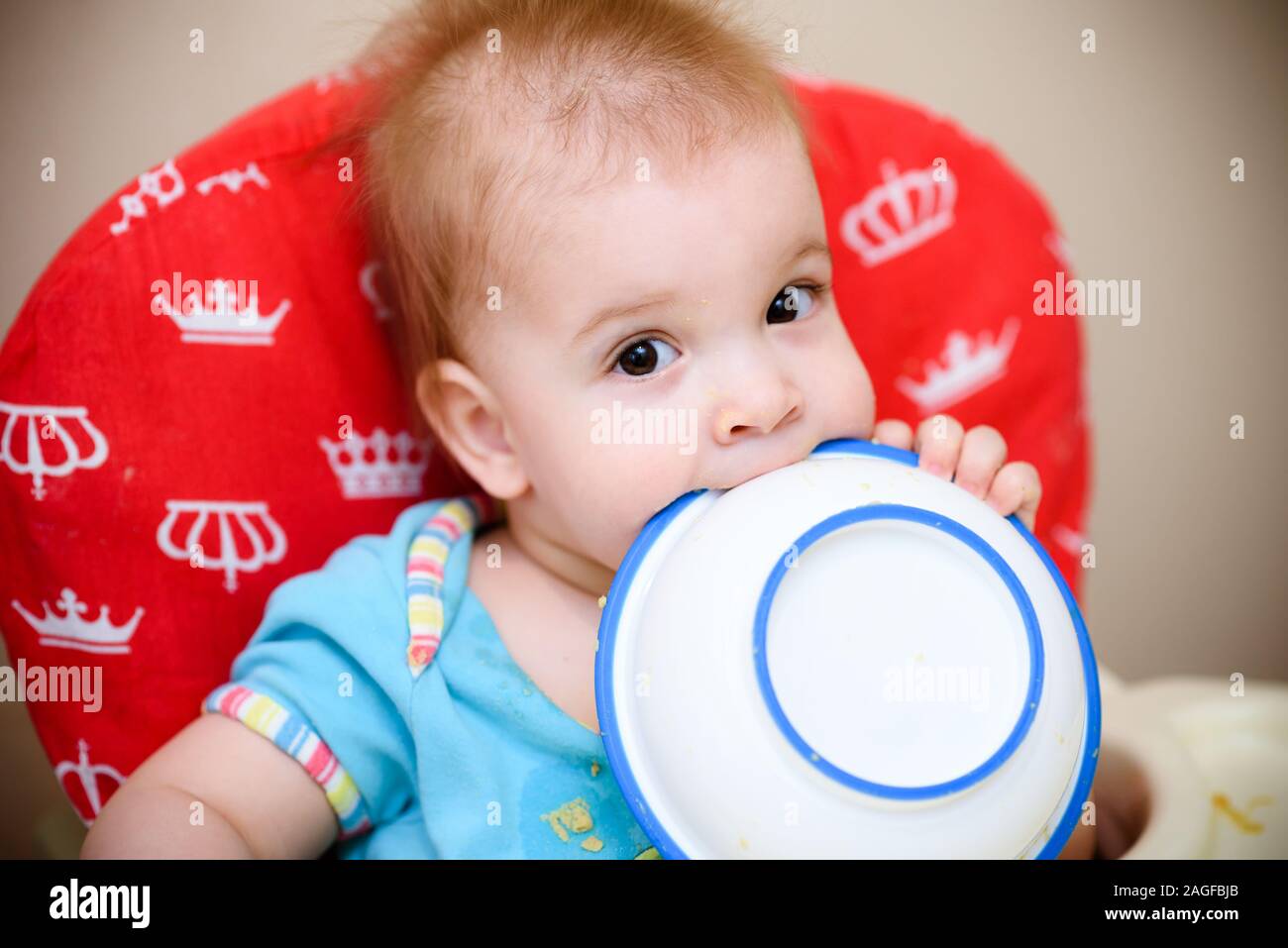 The kid is holding a plate in his mouth Stock Photo - Alamy