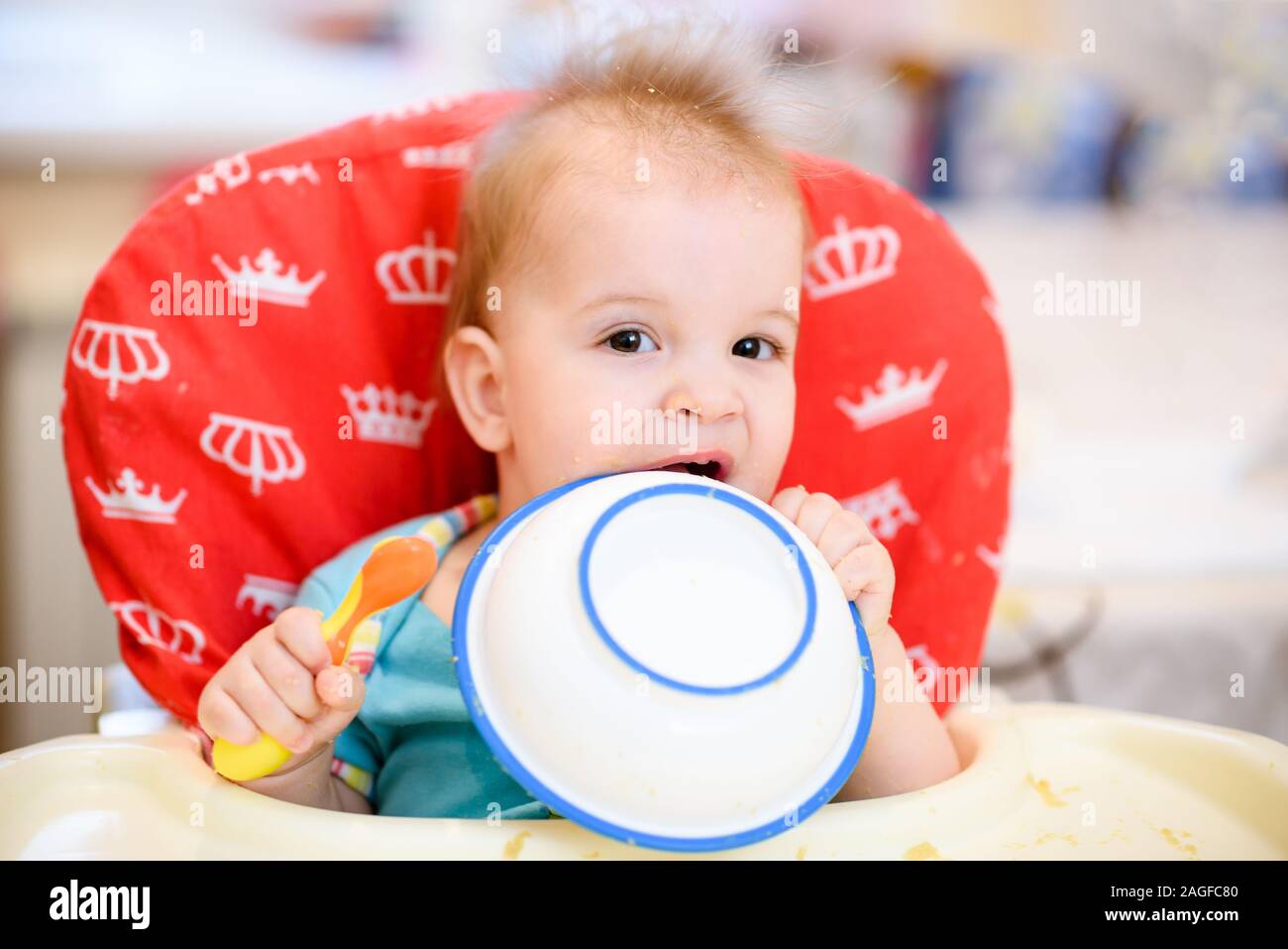 The kid is holding a plate in his mouth Stock Photo - Alamy