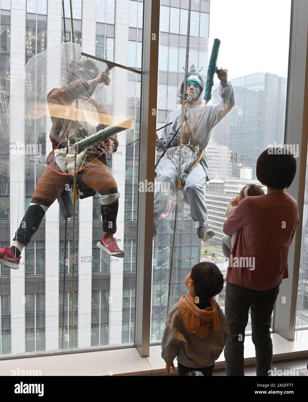 Tokyo, Japan. 19th Dec, 2019. Two Japanese window cleaners wearing ...