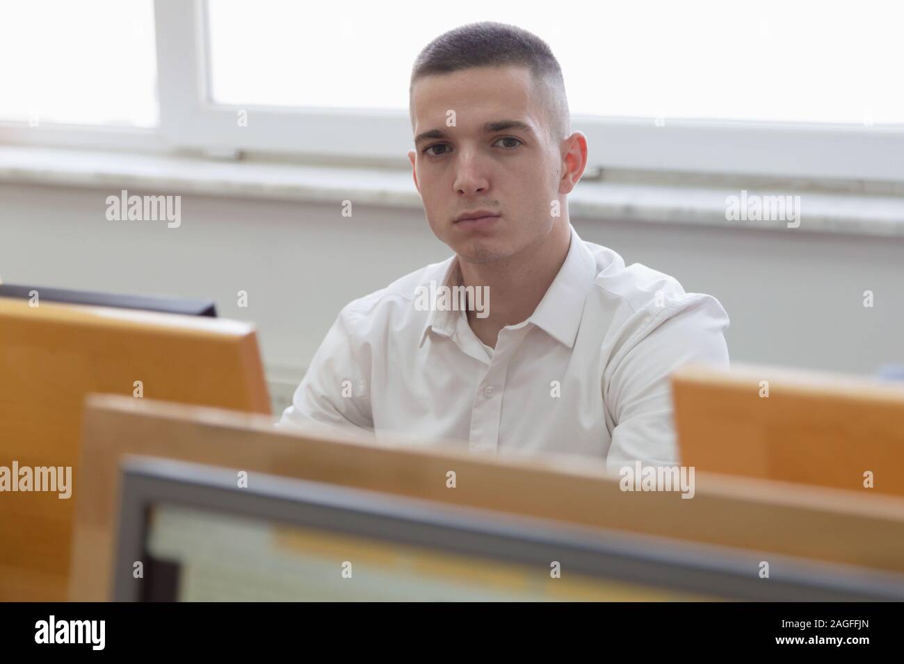 University Male student looking into camera inside computer room during ...
