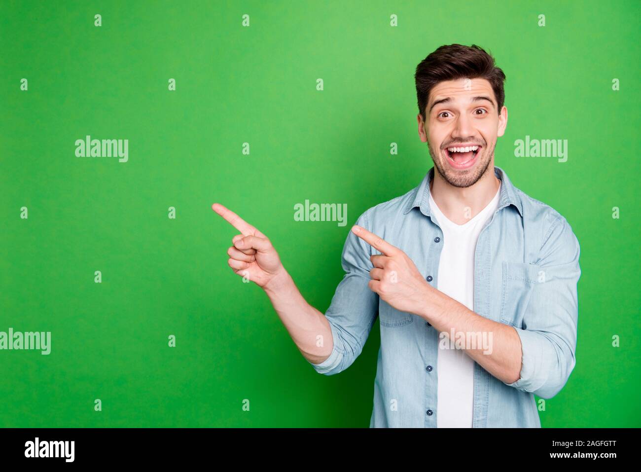 Photo of cheerful positive handsome man pointing at empty space ...