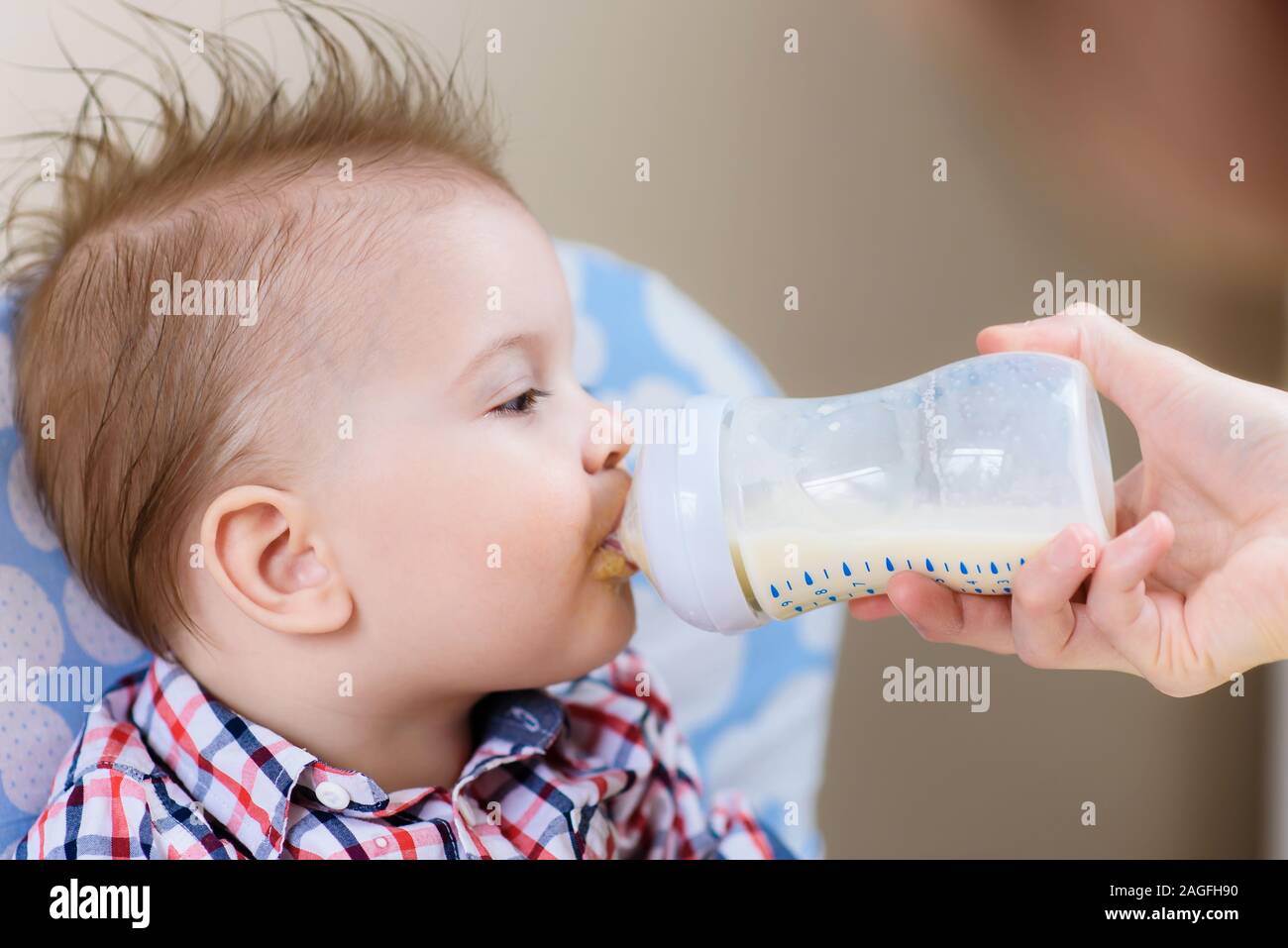 woman gives to drink baby milk in the house Stock Photo - Alamy