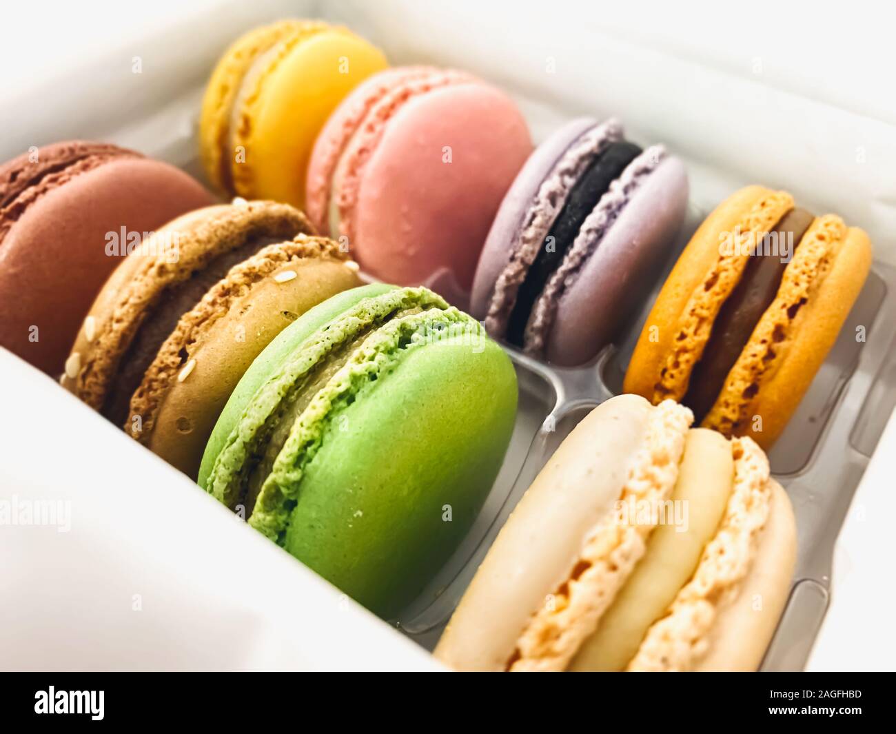 a group of colorful macarons stacked in a plastic package. Meringue ...