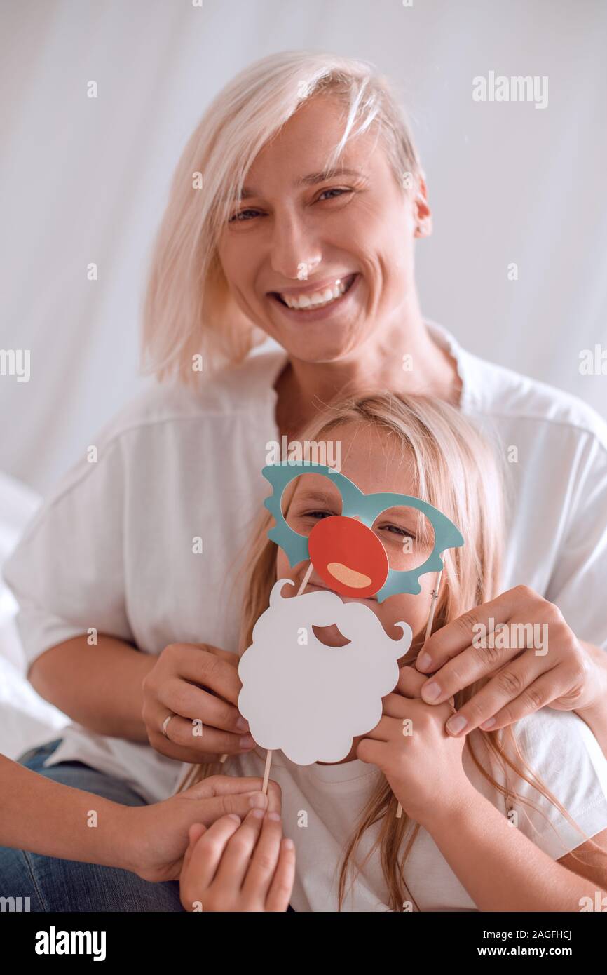 close up. mother dressing daughter merry mask Stock Photo - Alamy