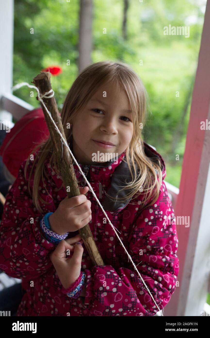 Young girl smiling holding a self-made bow and arrow Stock Photo - Alamy
