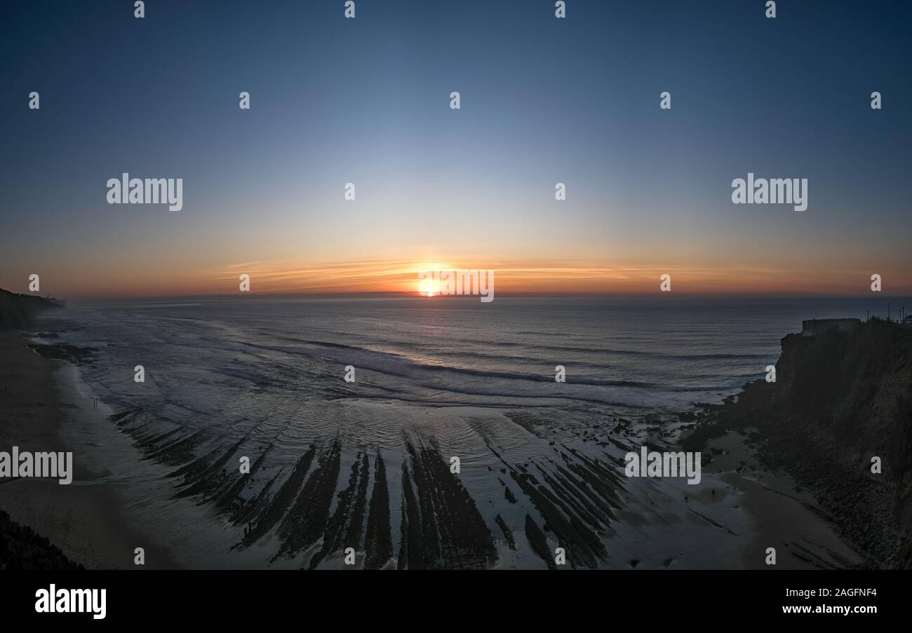 Beautiful scenery of the sunset reflecting in the ocean with its warm ...