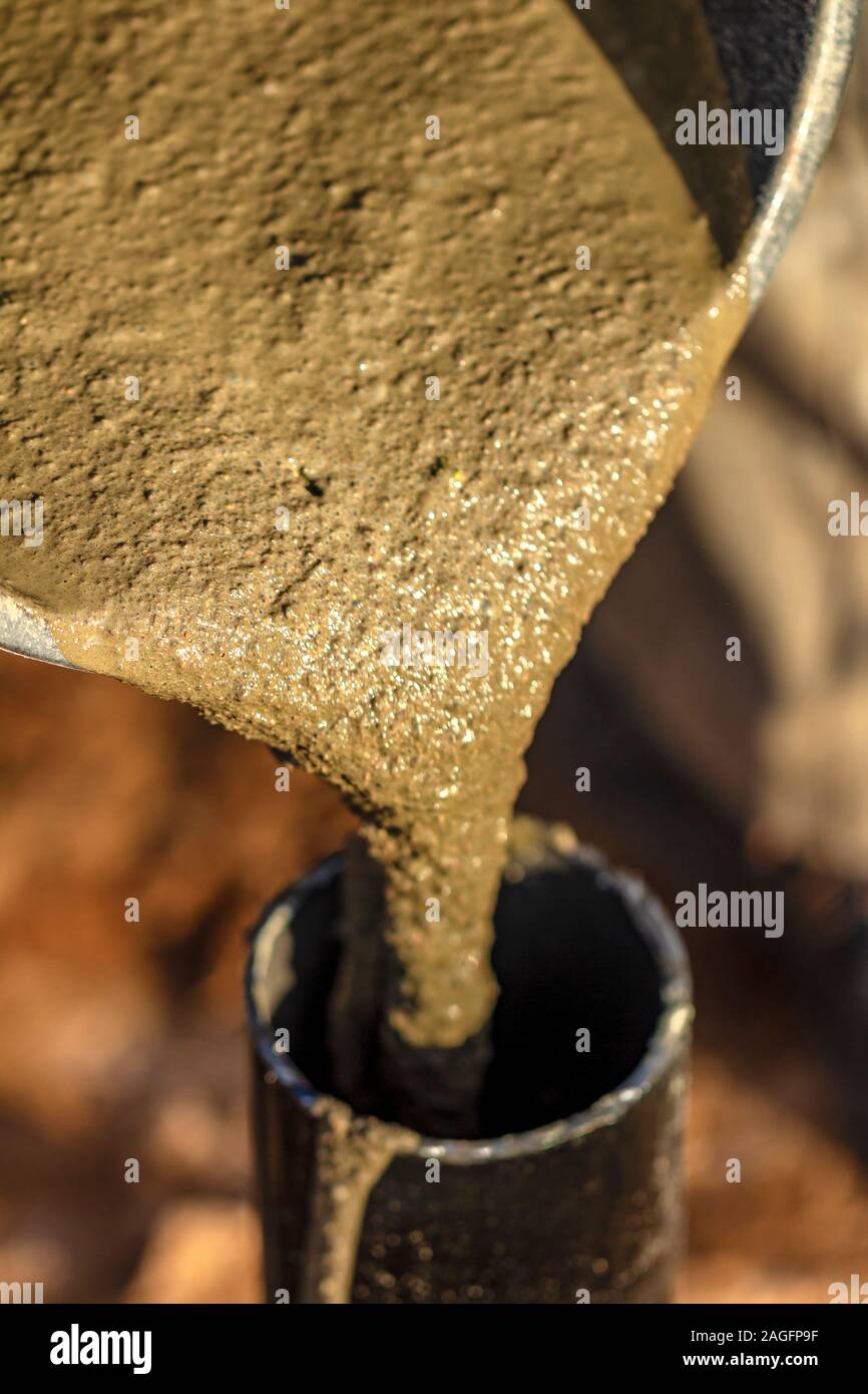 Pouring the concrete mixture into the pile Foundation. Cement work. The ...
