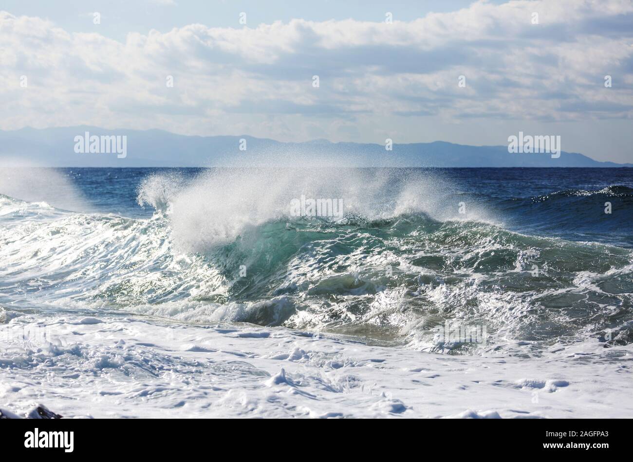 Man standing against the sea on a pier with big wave beating with ...