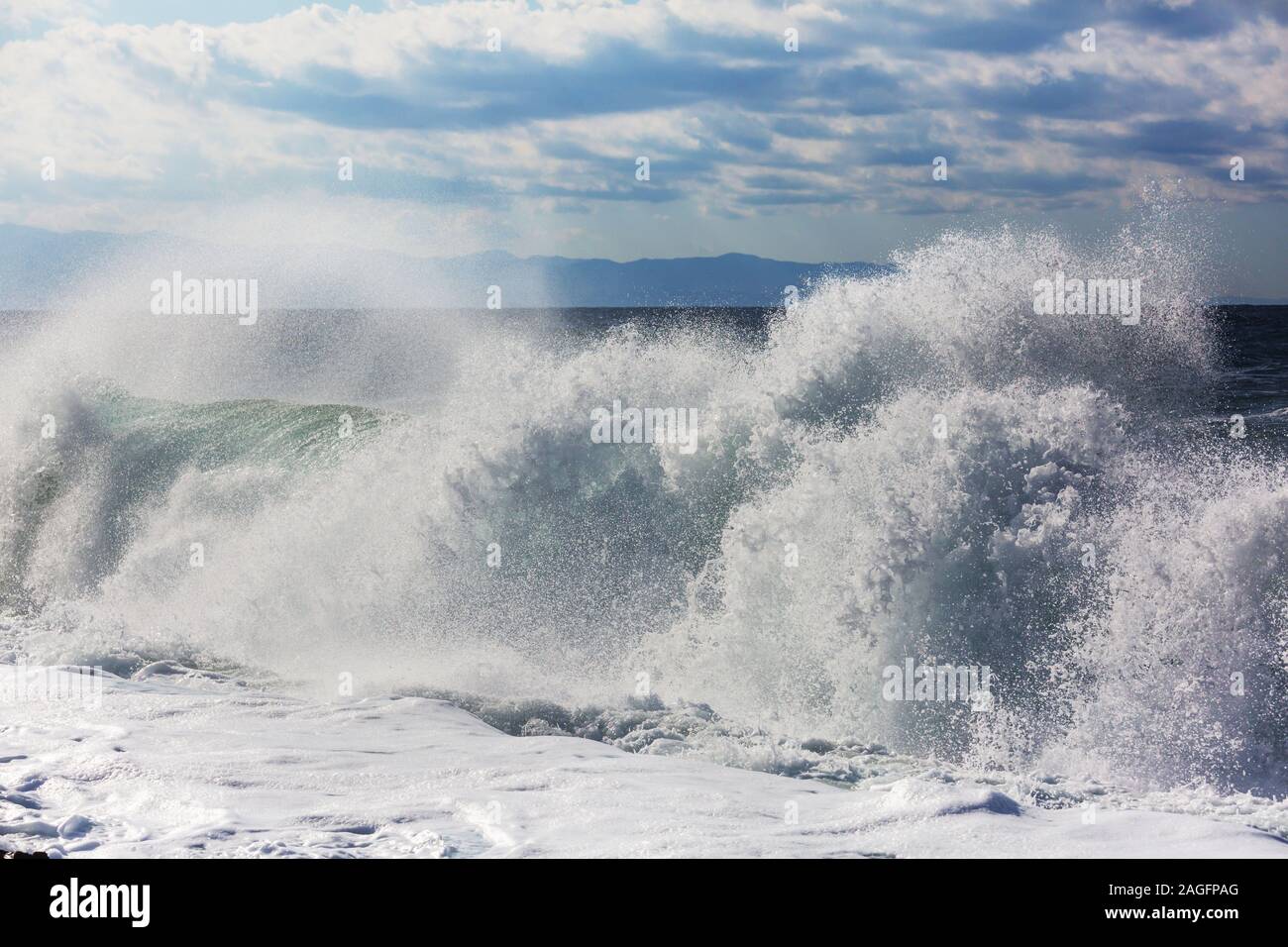 Man standing against the sea on a pier with big wave beating with ...