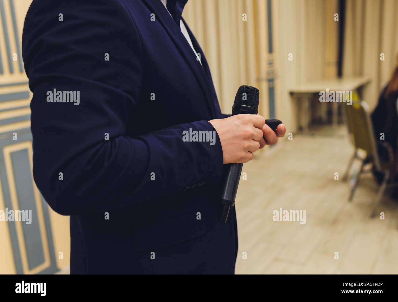 Mans hand holding a microphone conducting an interview Stock Photo - Alamy