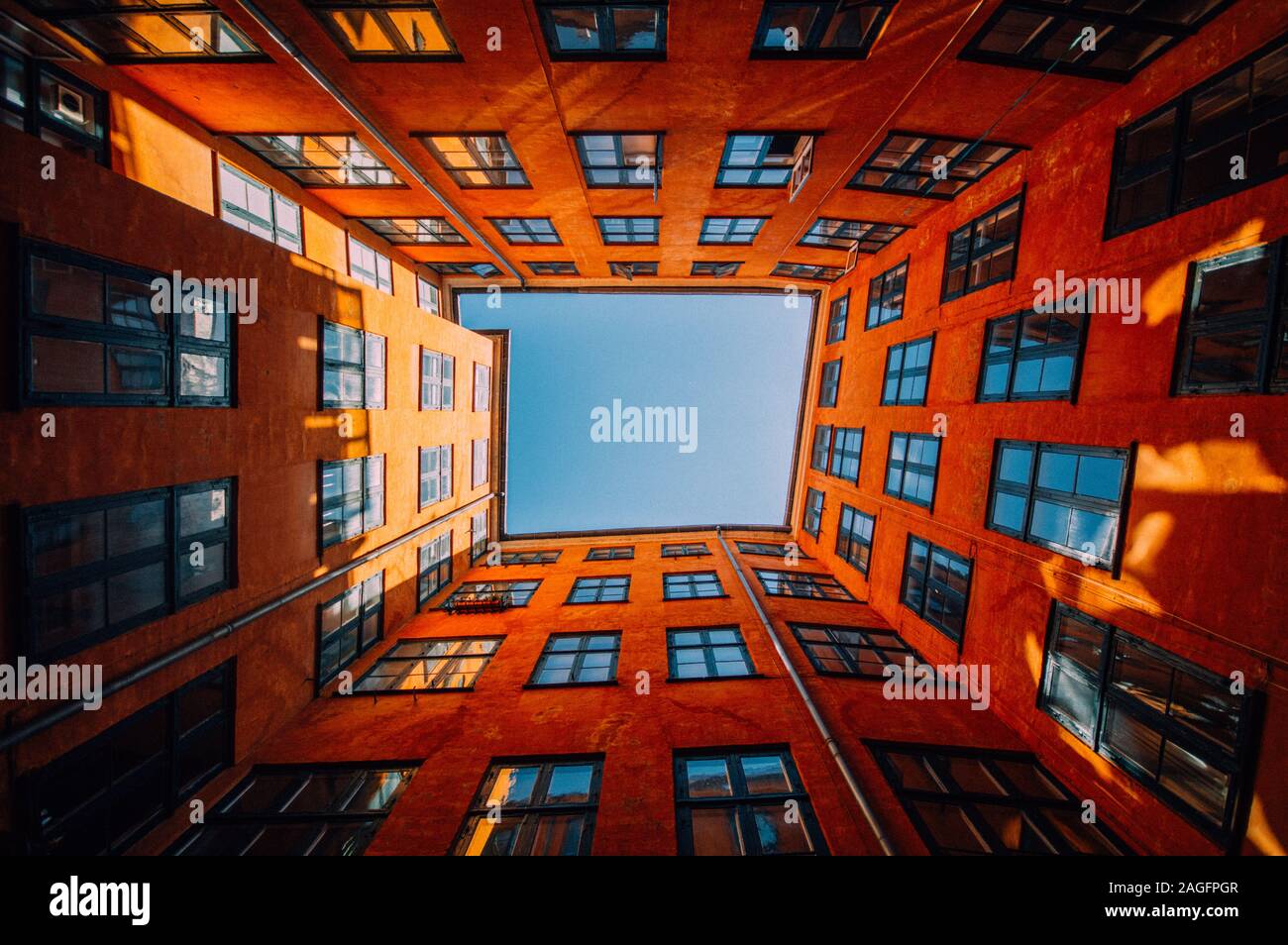 Low angle shot of a unique high rise orange building touching the sky ...