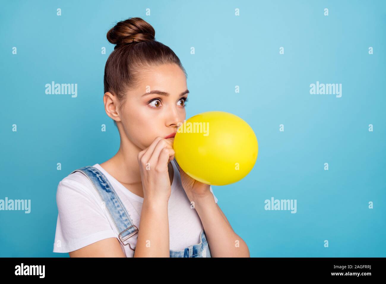 Turned photo of shocked person inflating baloon looking wearing white t ...