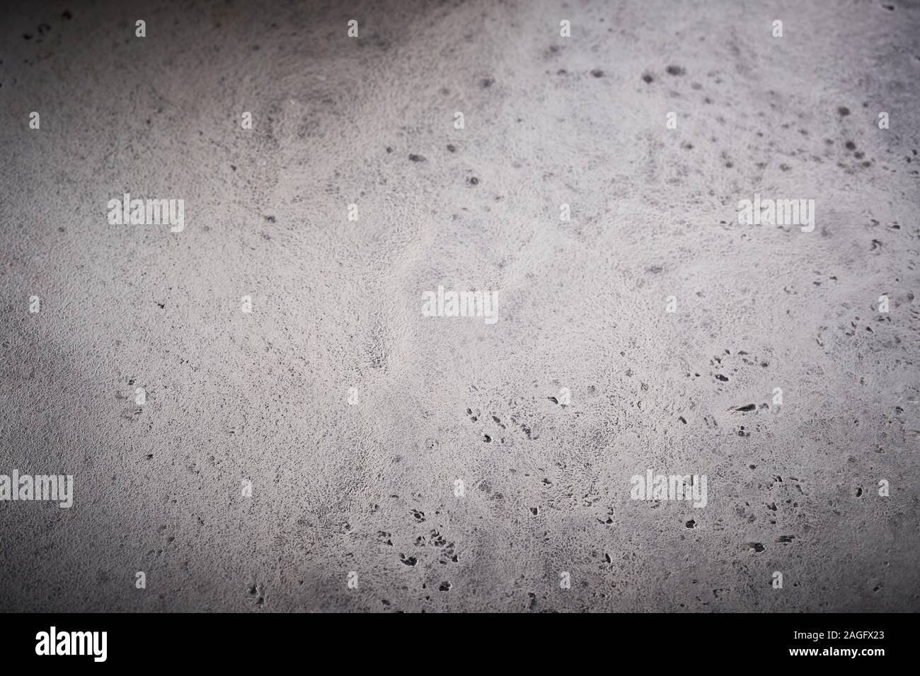 Full frame textured pitted grey cookware background with vignette for ...