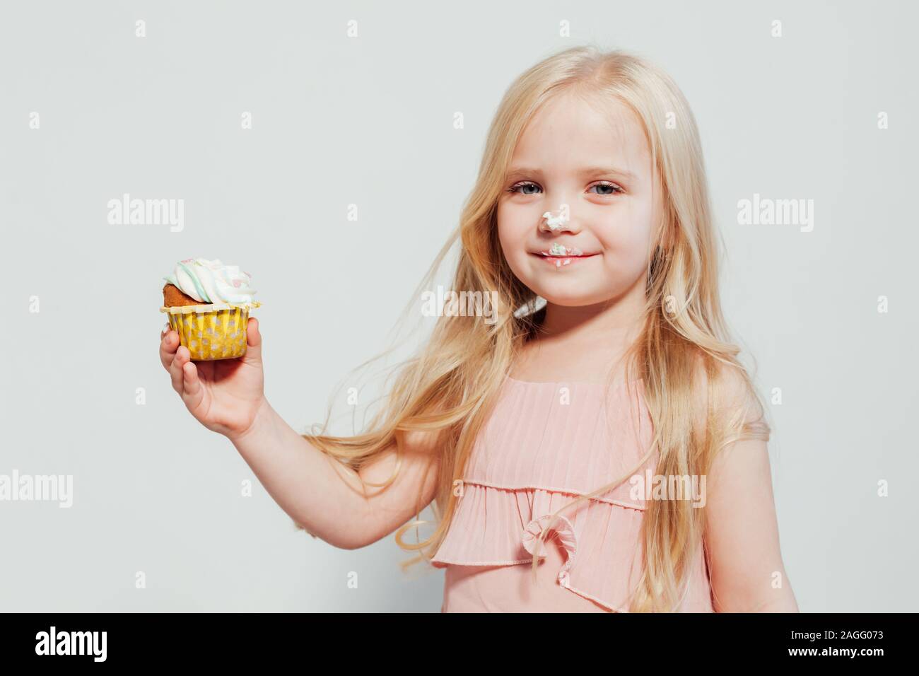 little girl eating cake with cream cupcake sweet Stock Photo - Alamy