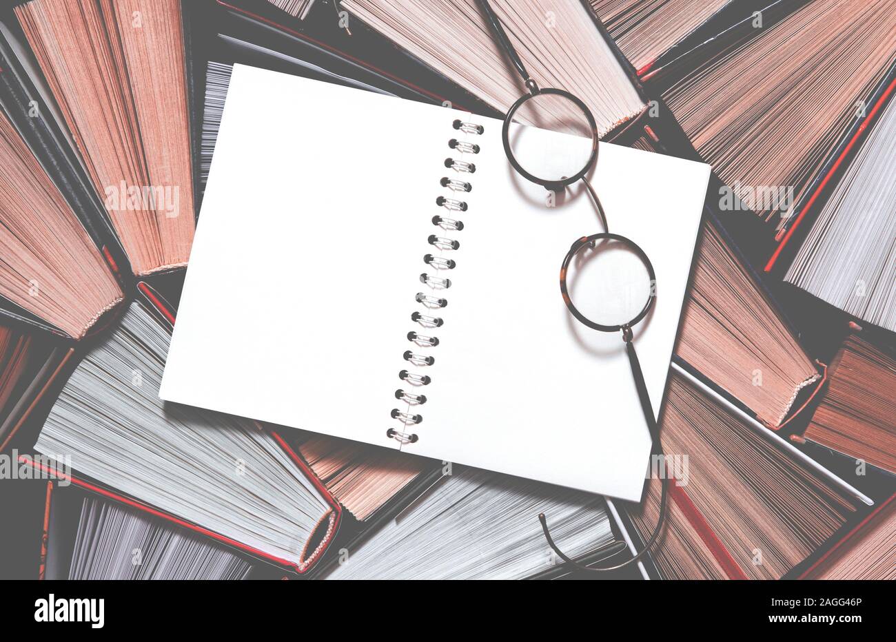 Many multicolored thick open books stand on a dark background. On the ...