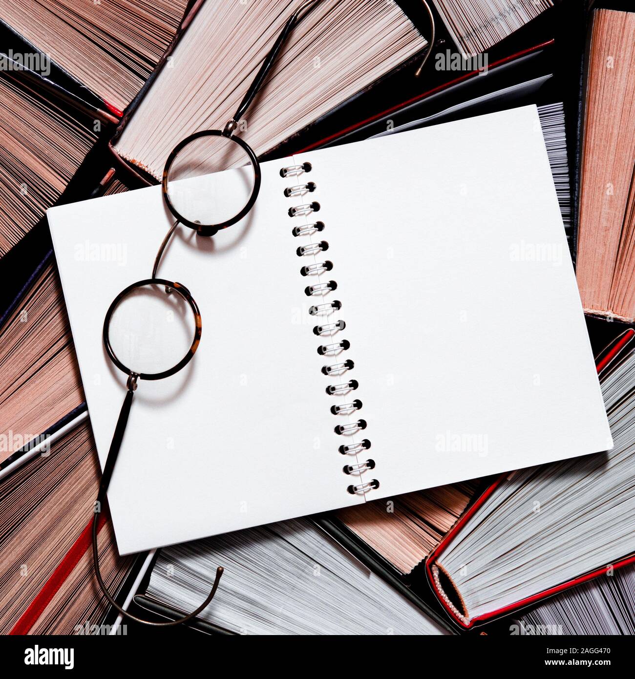 Many multicolored thick open books stand on a dark background. On the ...