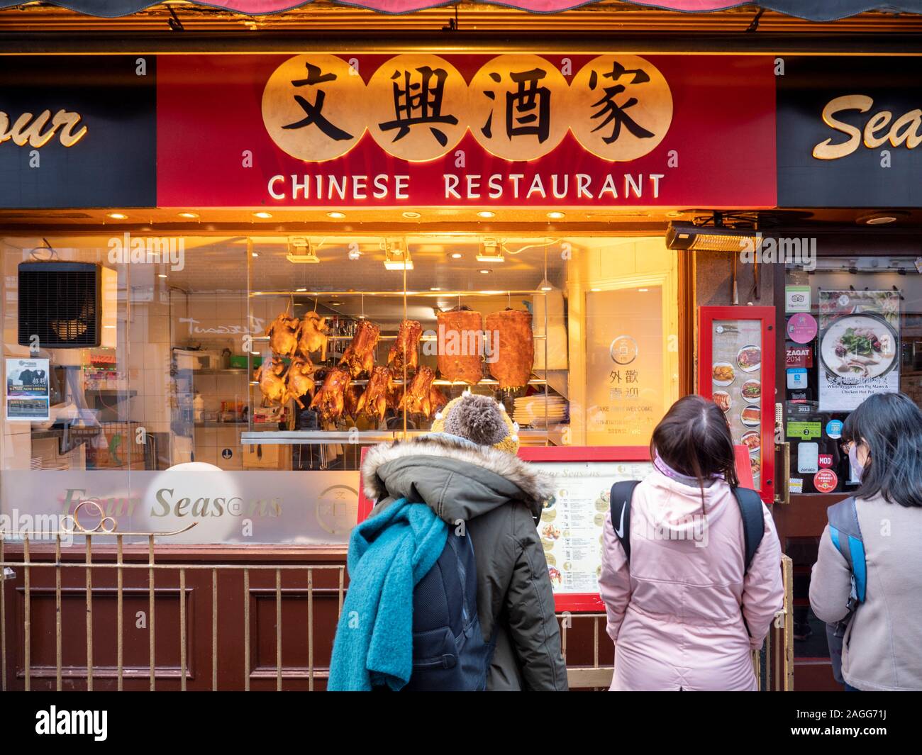 People looking in the window of a chinese restaurant in Gerard Street ...