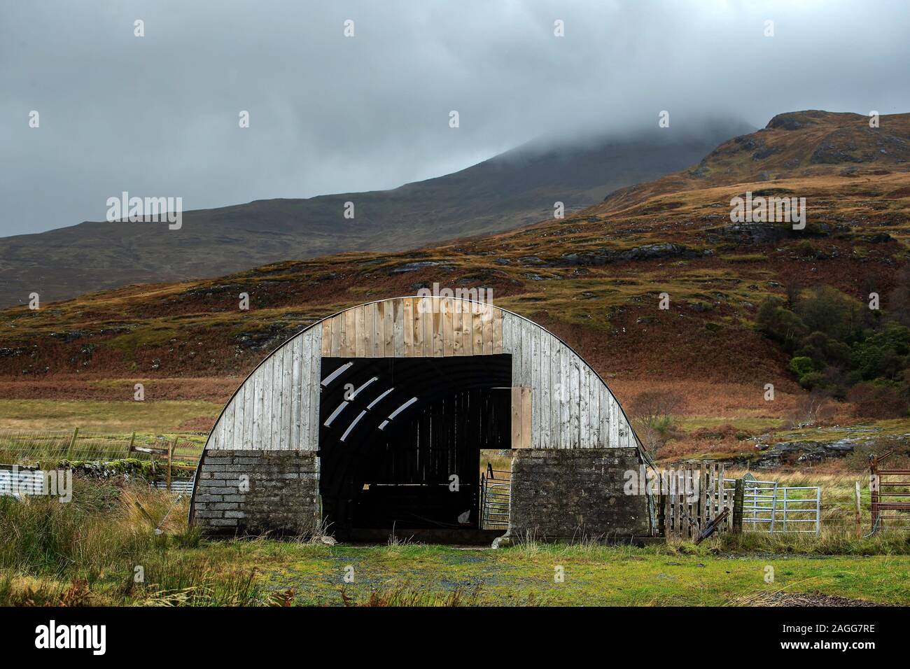 Low cloud over and old Nissen hut barn (front view) on a moorland ...