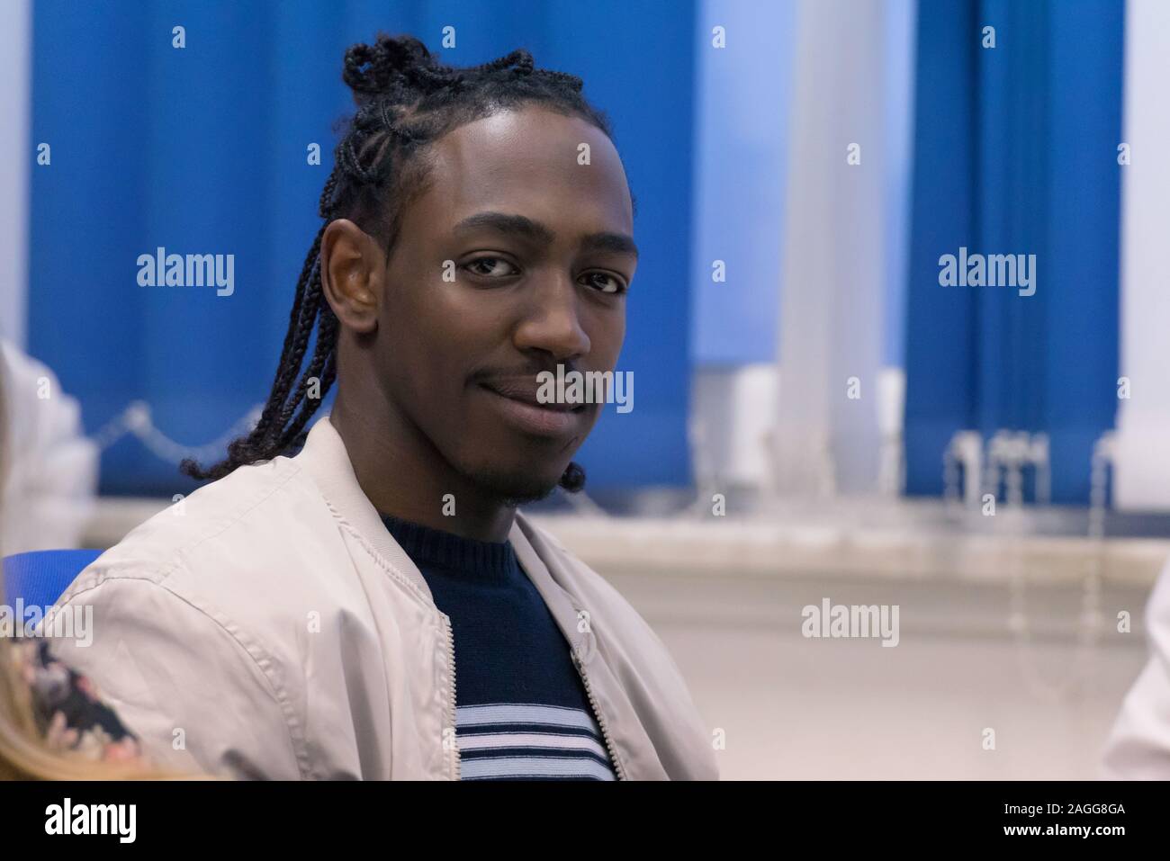 Smiling african american university male student in class sits at his ...