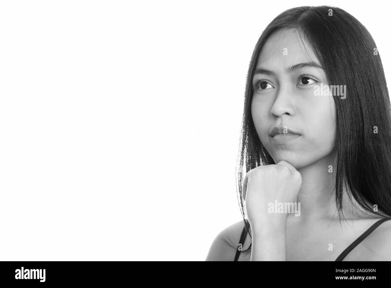 Studio shot of young Asian teenage girl thinking Stock Photo - Alamy