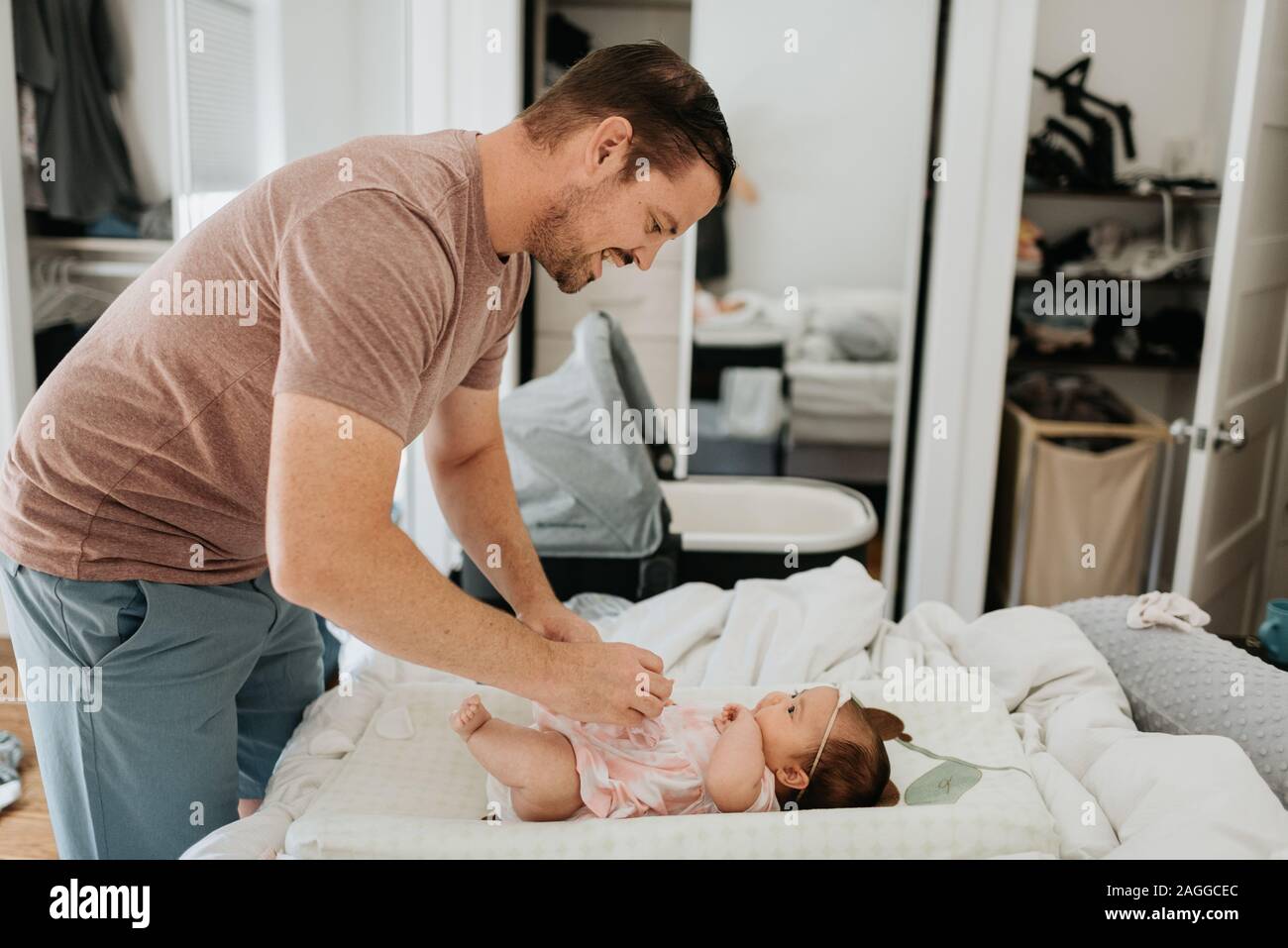 Father changing diaper of baby girl on changing table Stock Photo - Alamy