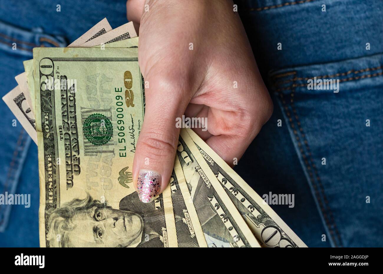 Woman hand taking money from jeans back pocket. Woman hiding money ...