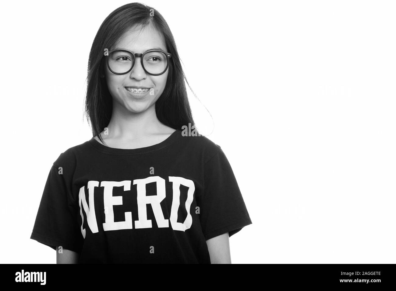 Studio shot of young happy Asian teenage nerd girl smiling while thinking Stock Photo - Alamy