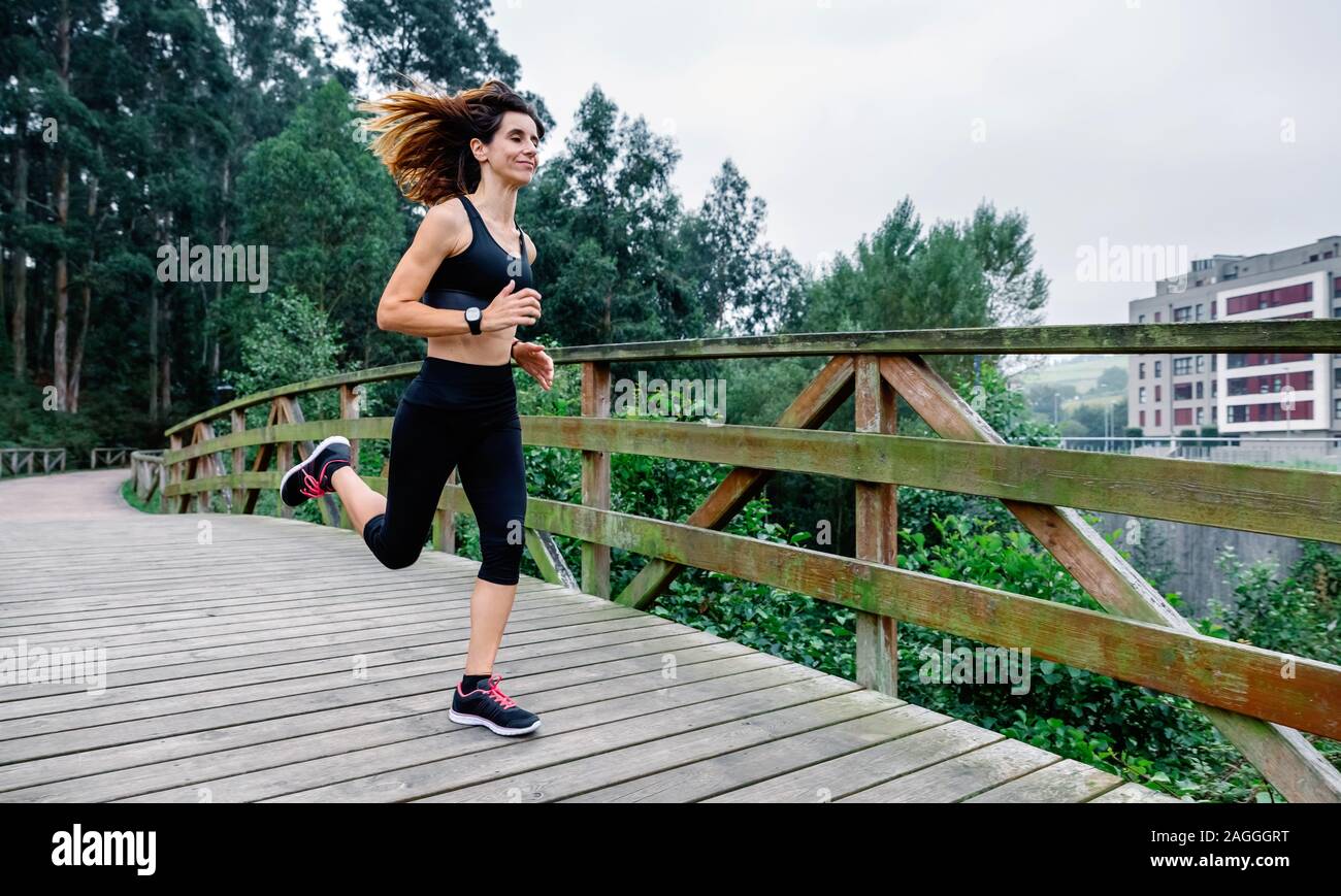 Woman running through an urban park Stock Photo - Alamy