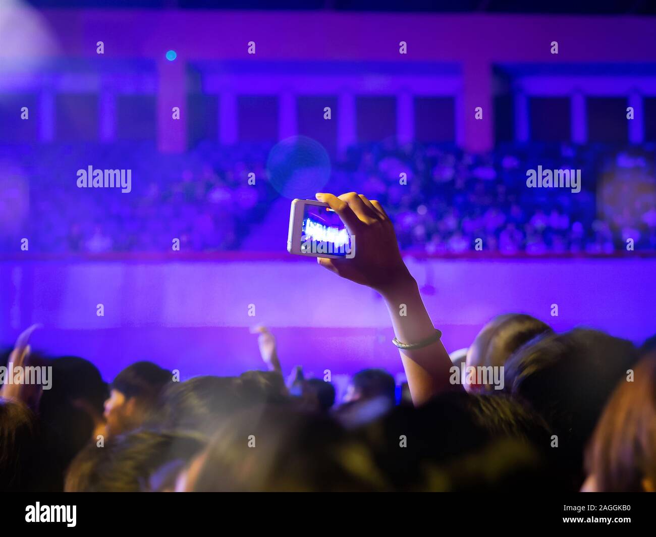 Some cheering fans take a photograph or video with smartphone in a free ...