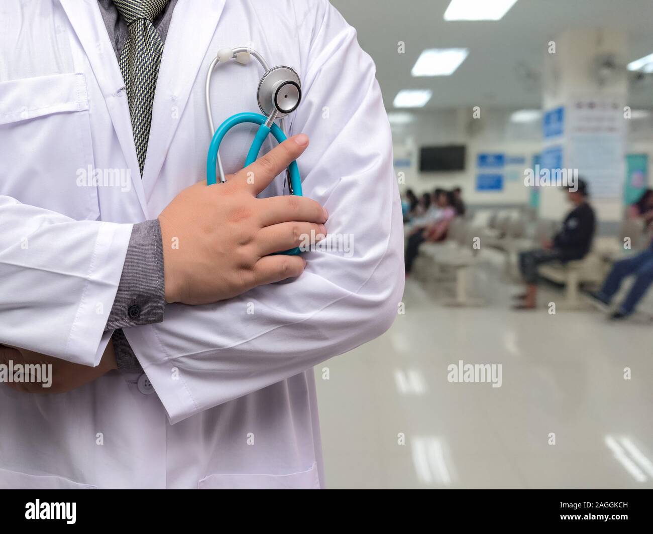 Doctor in gown uniform with stethoscope standing and fold his arms over ...