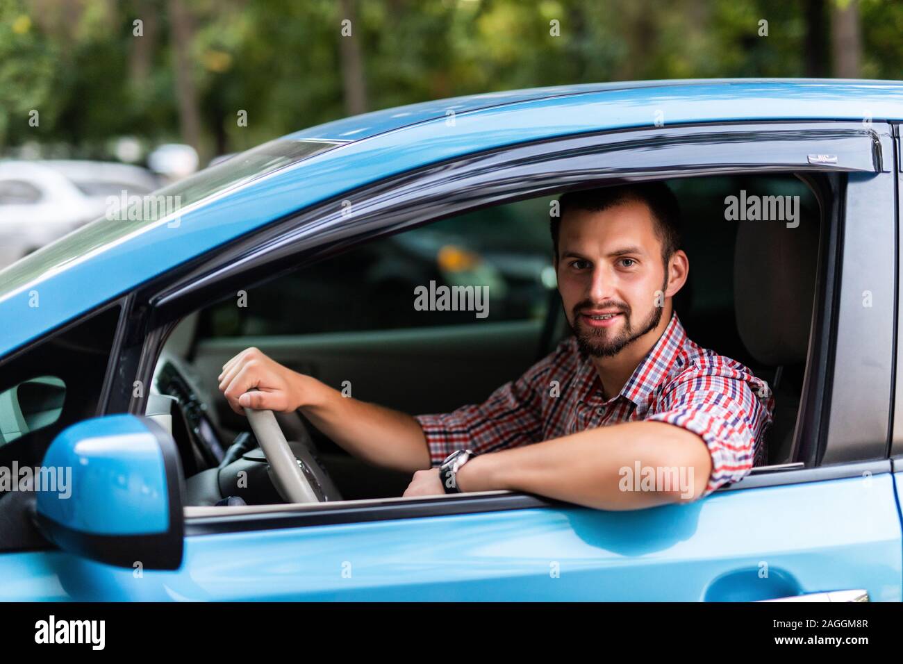 Young man drive his new electric car on the city road Stock Photo - Alamy