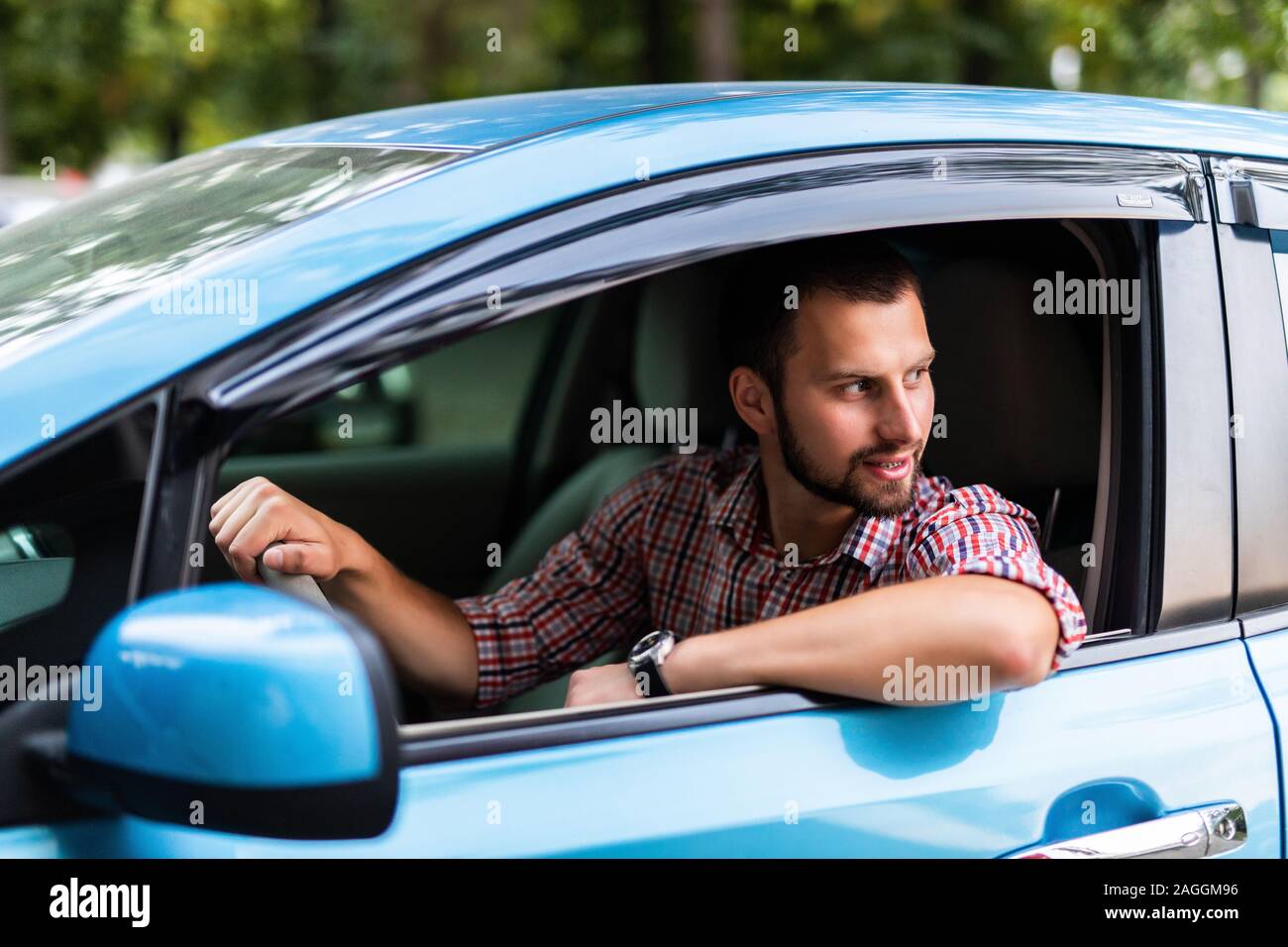 Electric car driver - green energy biofuel concept. Male behind wheel ...