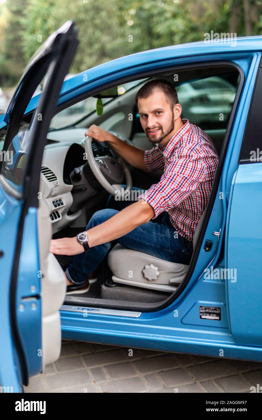 Electric car driver - green energy biofuel concept. Male behind wheel ...