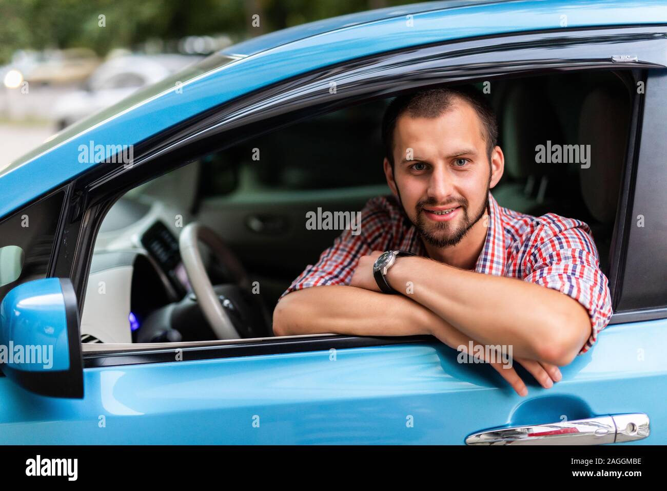 Young man drive his new electric car on the city road Stock Photo - Alamy