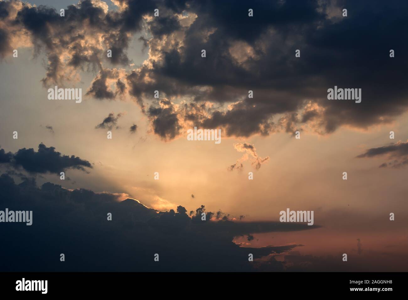 The sun setting behind dark clouds, sun rays and colorful sky Stock ...