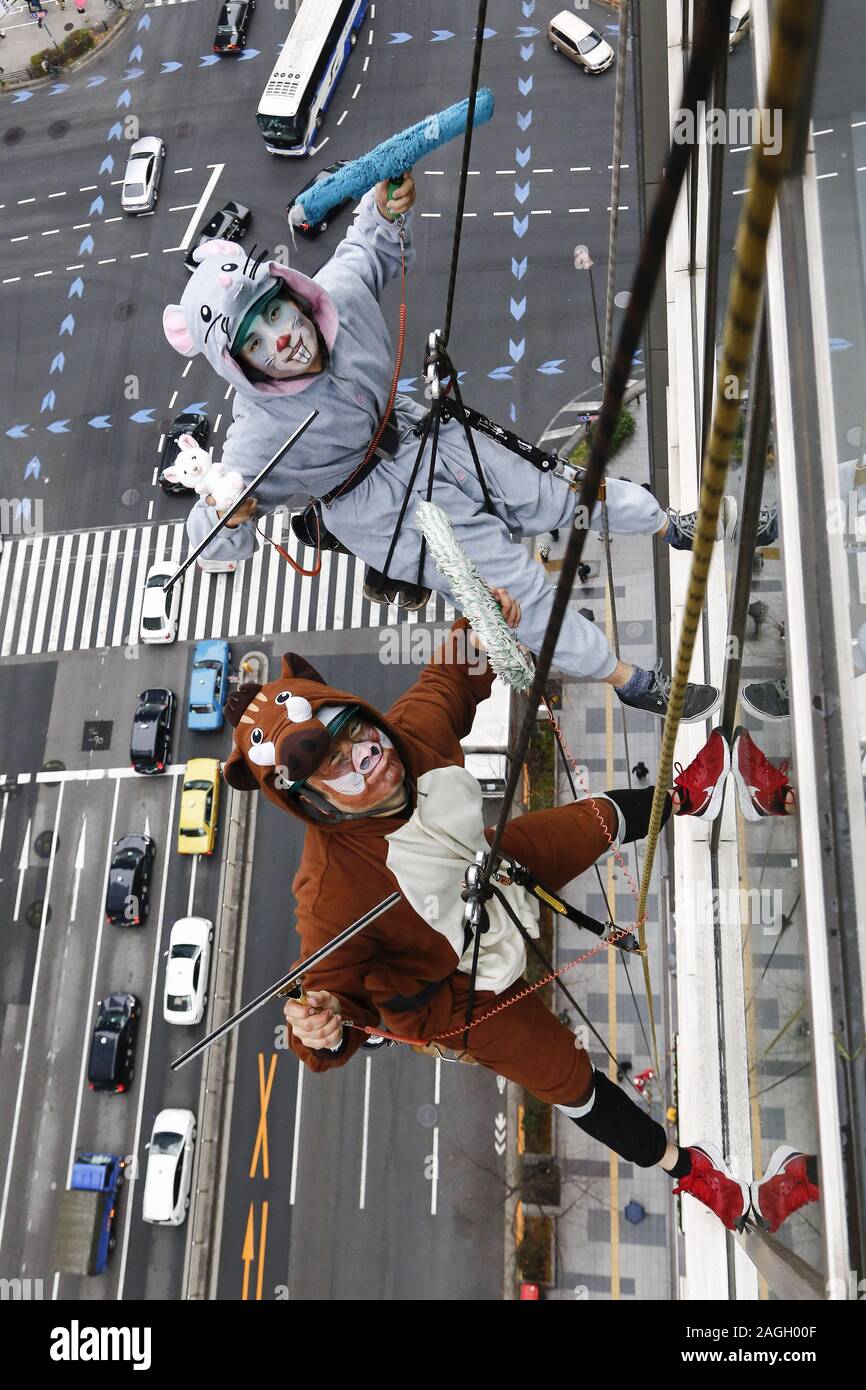 Tokyo, Japan. 19th Dec, 2019. Window cleaners dressed as a wild boar ...