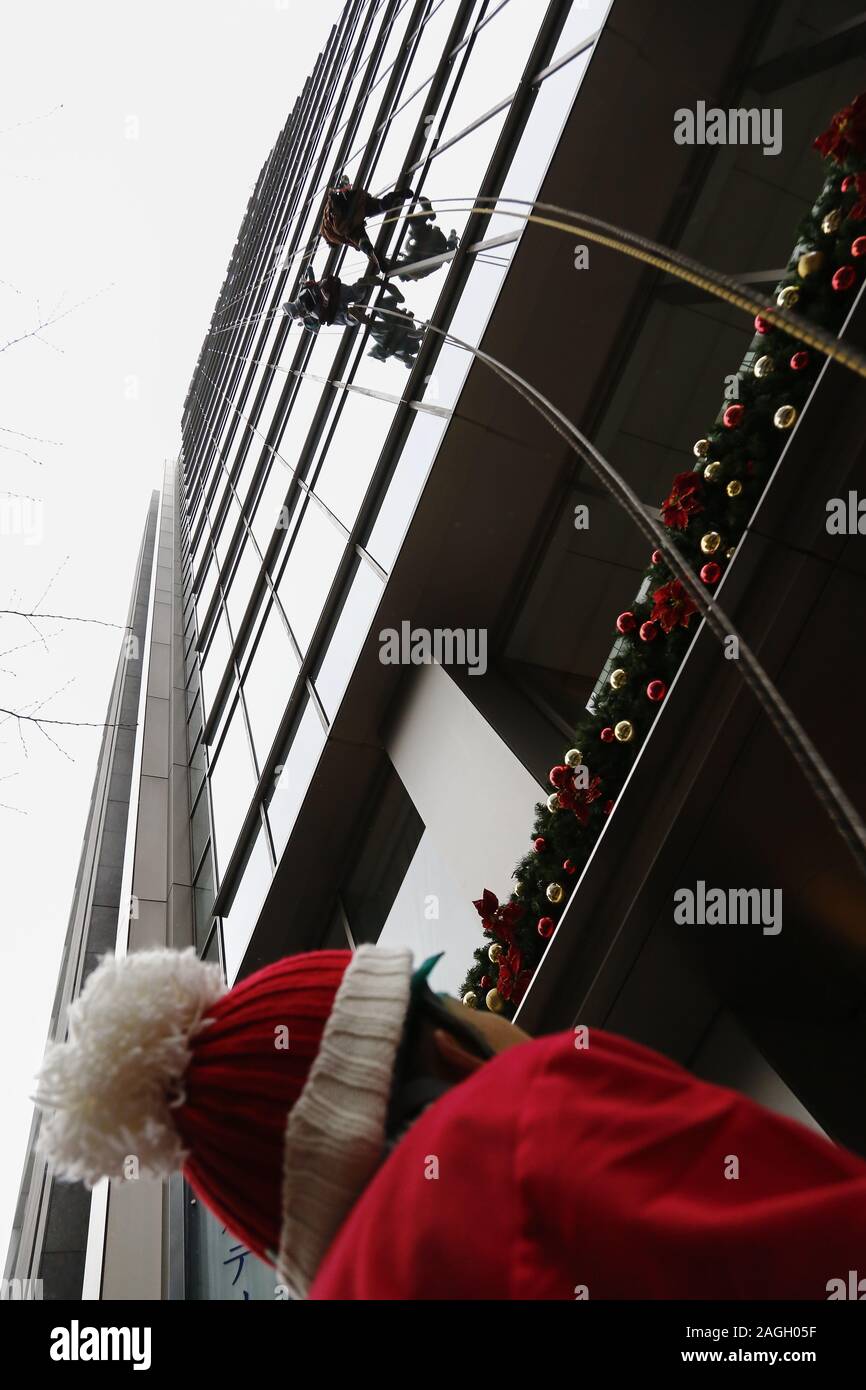 Tokyo, Japan. 19th Dec, 2019. Window cleaners dressed as a wild boar ...