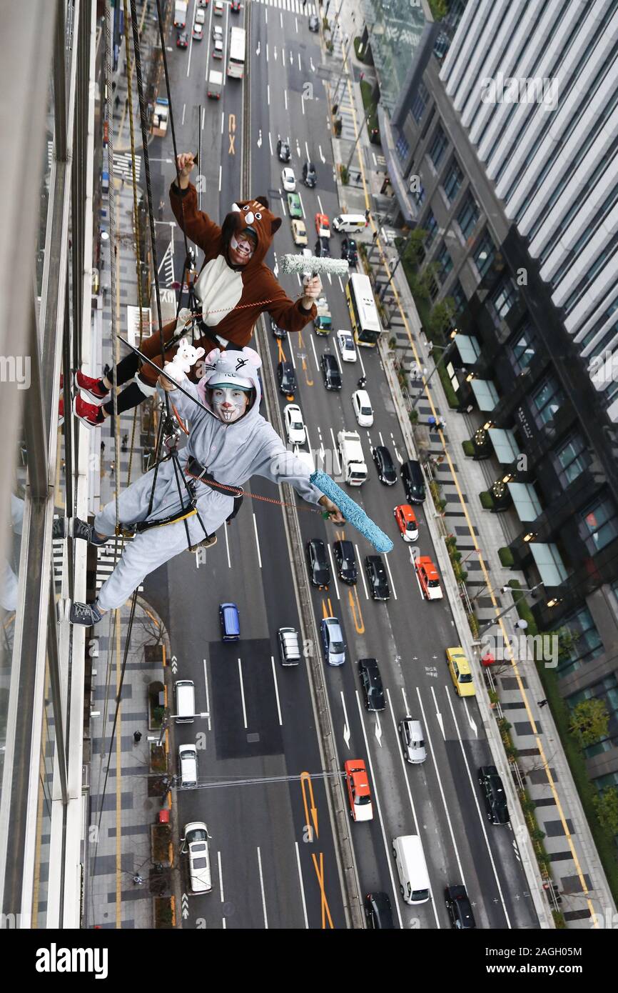 Tokyo, Japan. 19th Dec, 2019. Window cleaners dressed as a wild boar ...