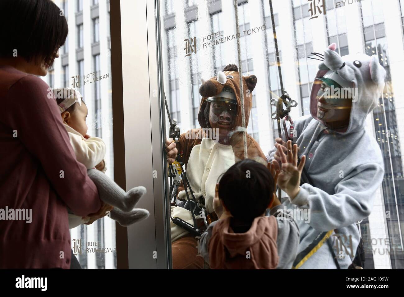 Tokyo, Japan. 19th Dec, 2019. Window cleaners dressed as a wild boar ...