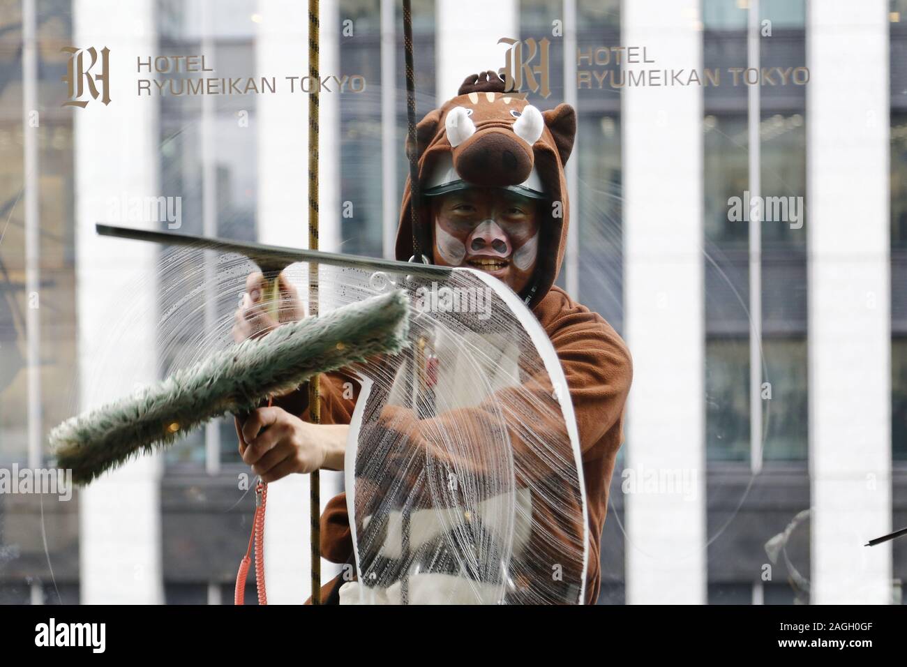 Tokyo, Japan. 19th Dec, 2019. A window cleaner dressed as a wild boar ...
